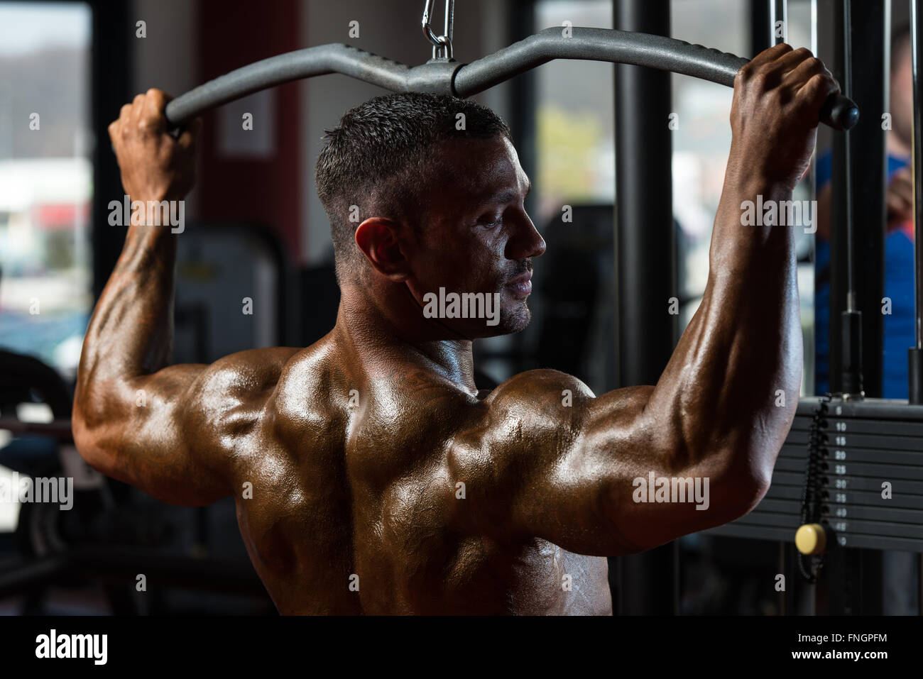 Bodybuilder Doing Heavy Weight Exercise For Back On Machine In Gym ...