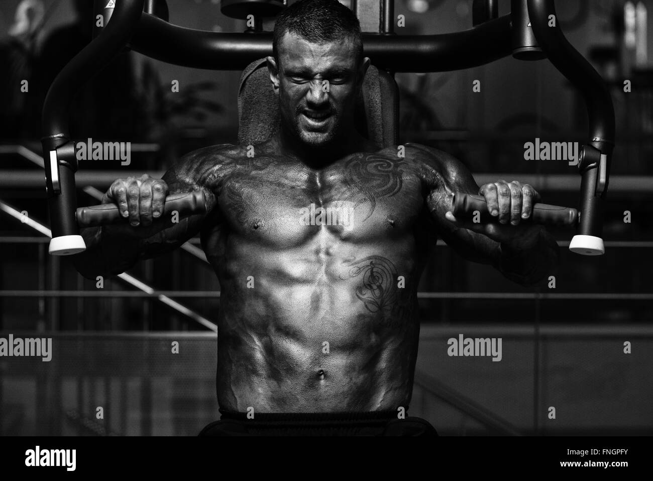 Adult Bodybuilder Doing Heavy Weight Exercise For Chest On Machine ...
