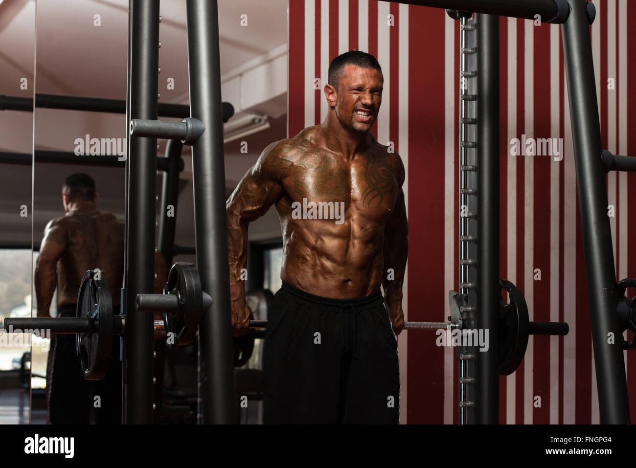 Male Bodybuilder Doing Heavy Weight Exercise For Trapezius Stock Photo ...