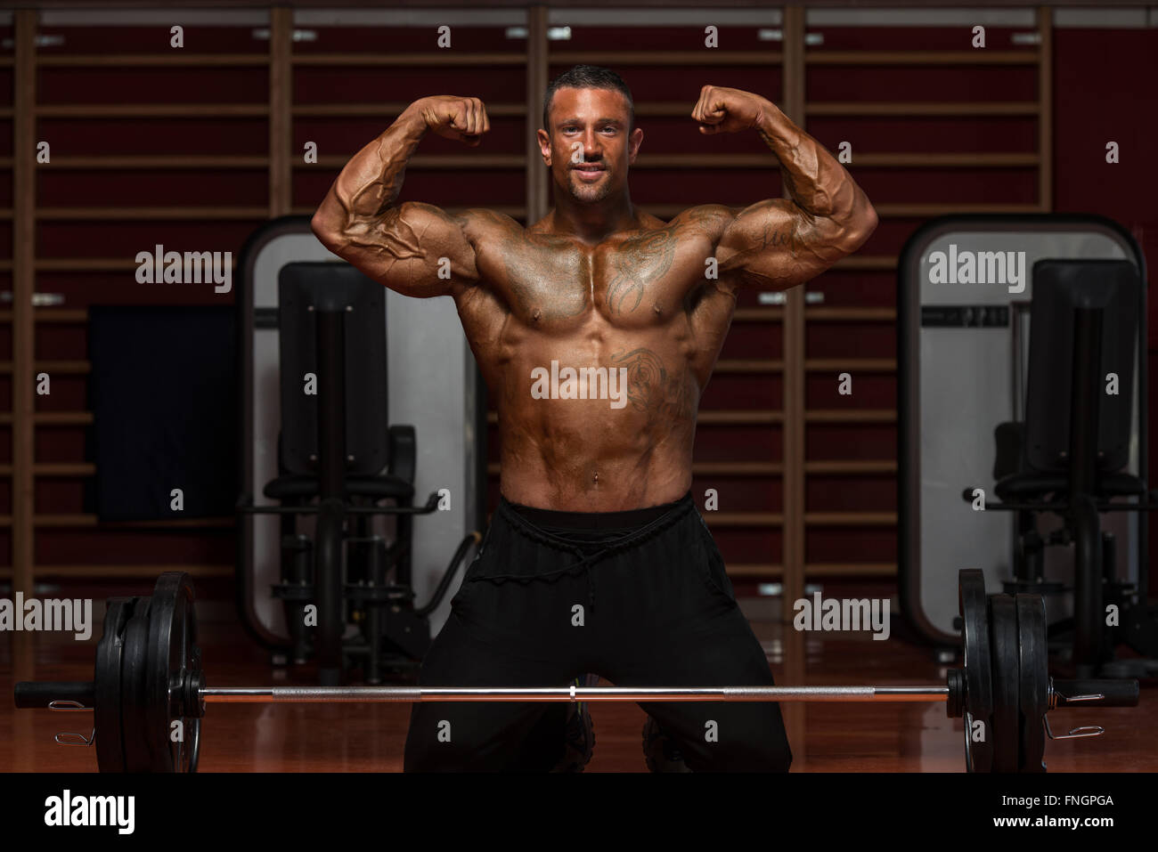 Serious Man Standing Strong In The Gym And Flexing Muscles Stock Photo ...