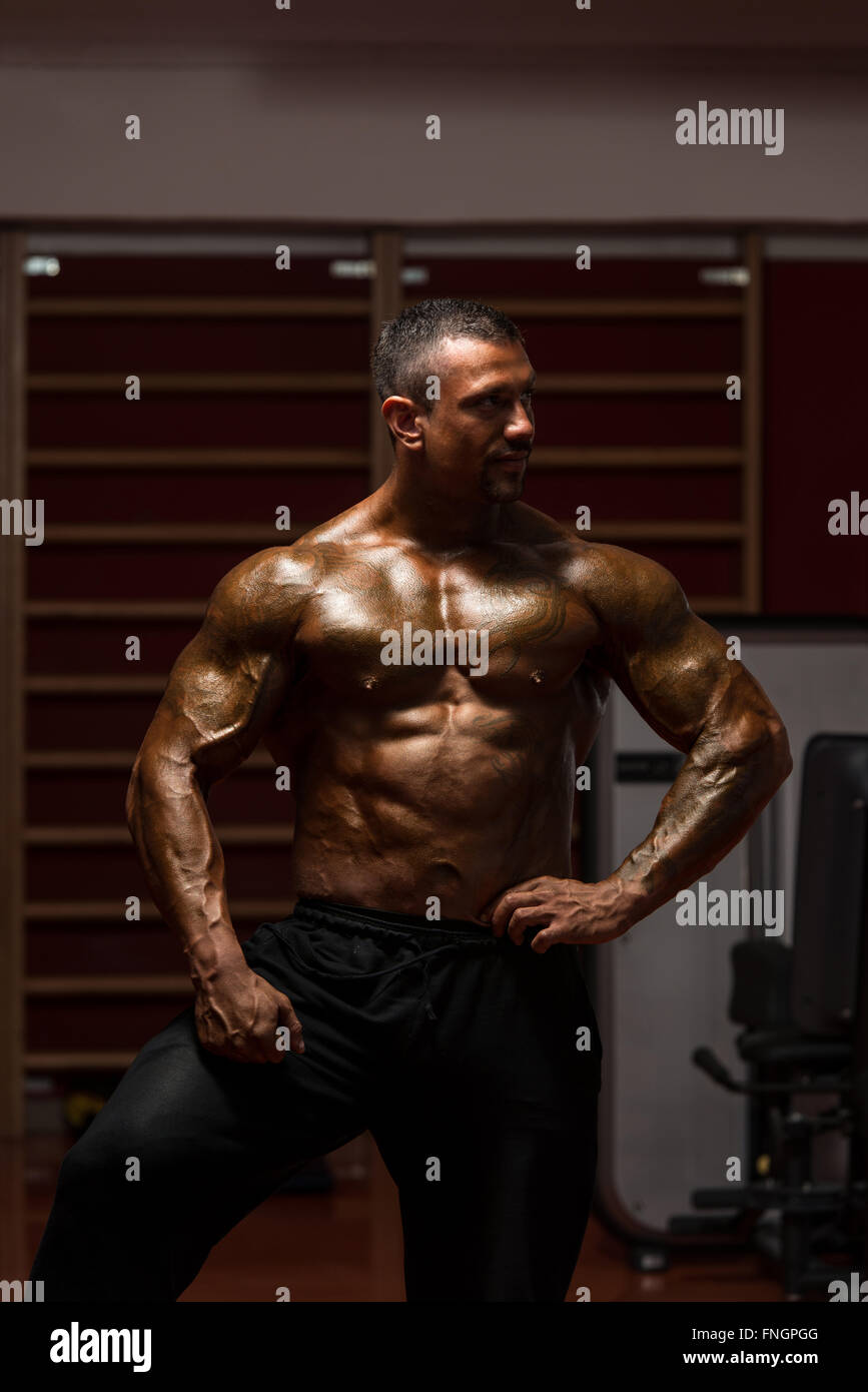 Serious Man Standing Strong In The Gym And Flexing Muscles Stock Photo ...