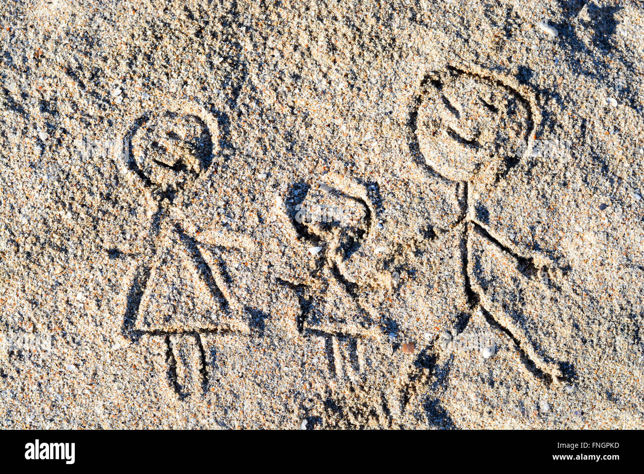 Happy family drawing on beach sand in the summer Stock Photo - Alamy