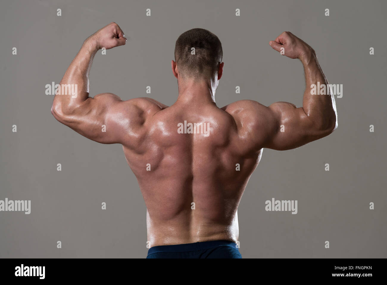 Serious Man Standing Strong In The Gym And Flexing Muscles Stock Photo ...