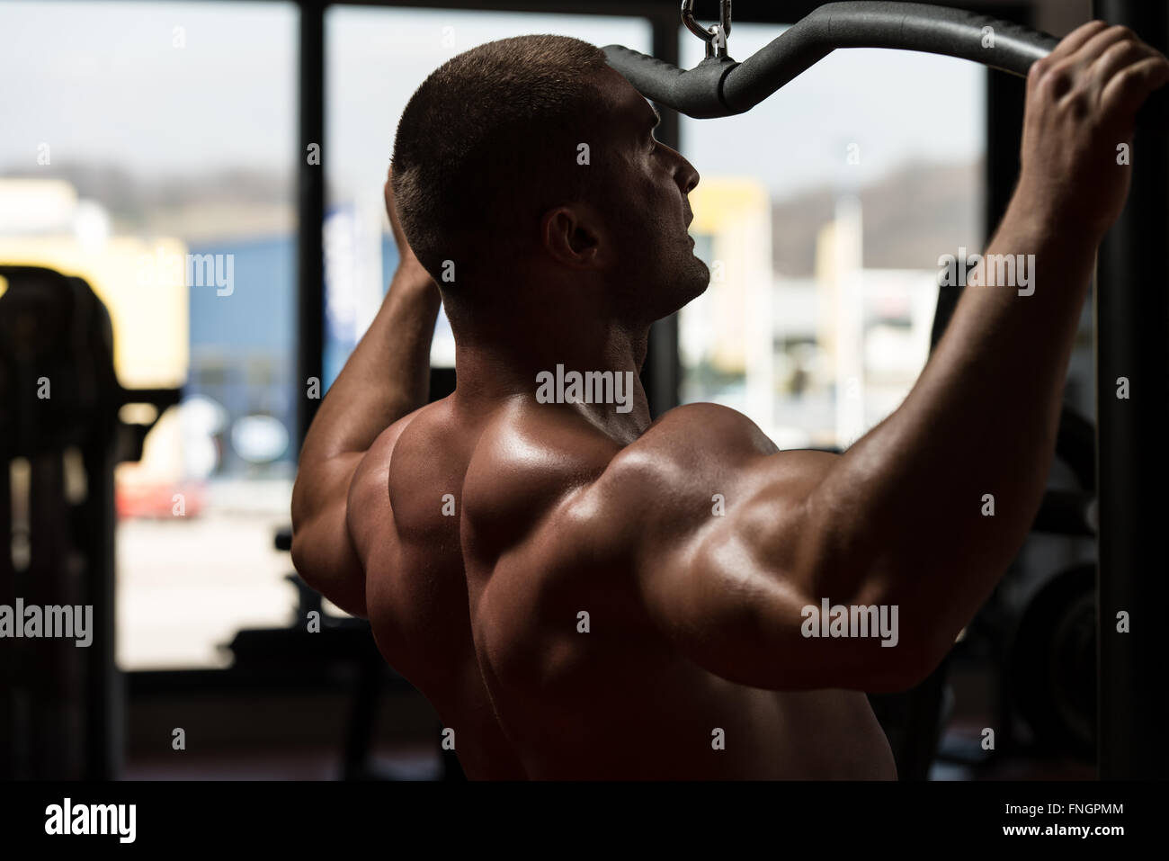 Bodybuilder Doing Heavy Weight Exercise For Back On Machine In Gym ...