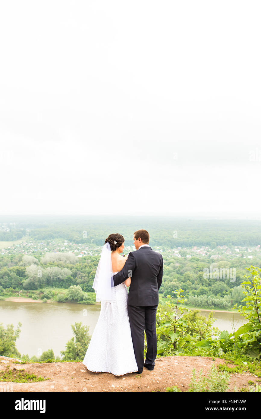 Back view of holding hands bride and groom outdoors Stock Photo - Alamy