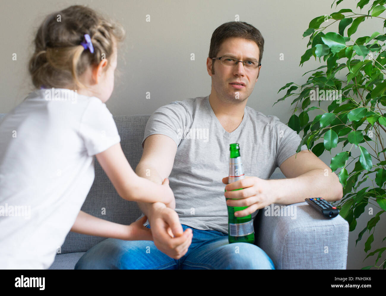 Little girl calling dad to play while he watching TV Stock Photo - Alamy