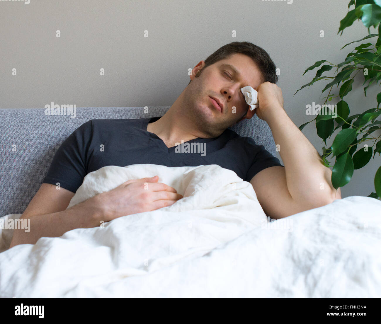 Sick man lying in the bed with fever Stock Photo - Alamy