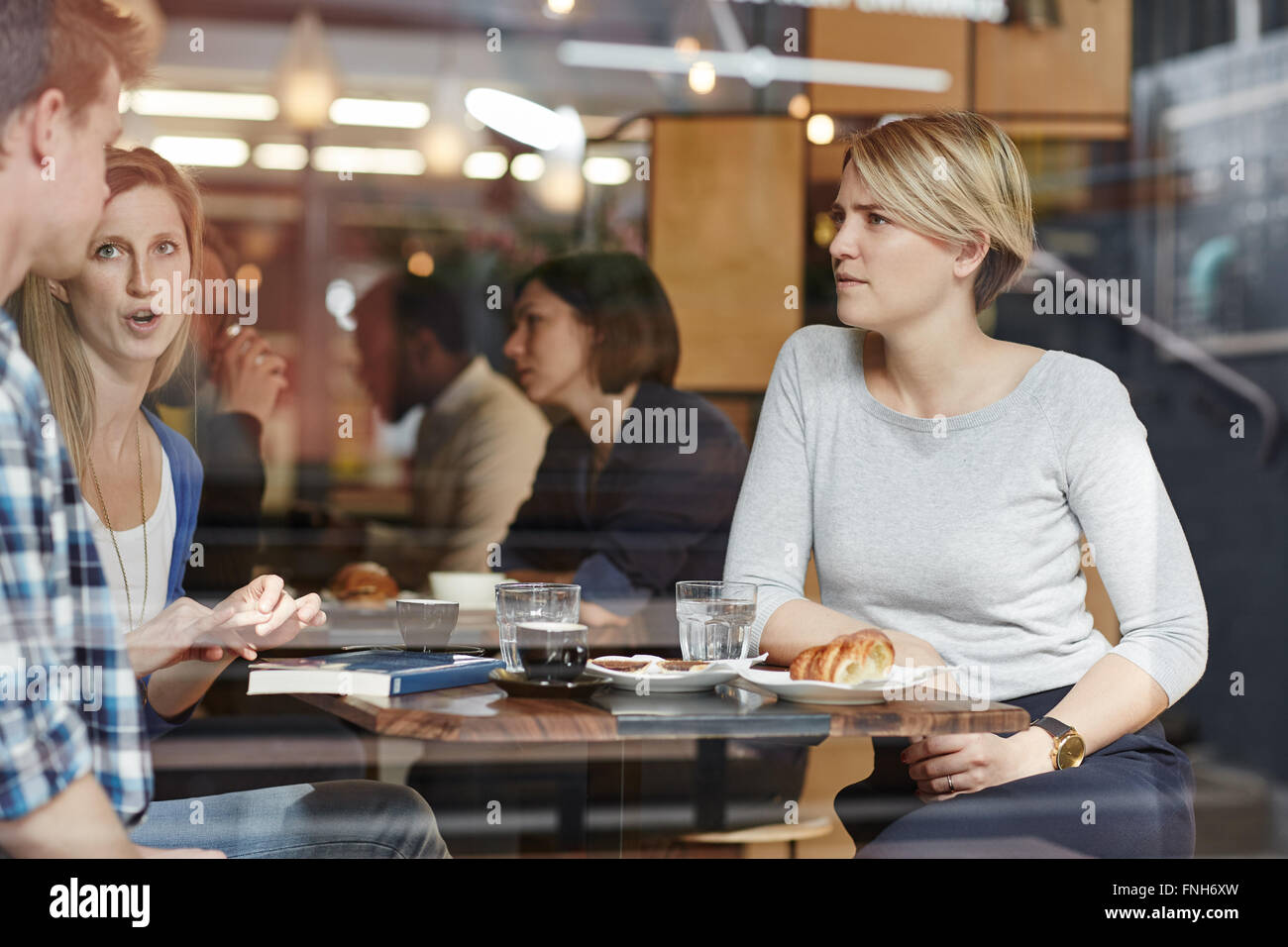 Friends talking on a coffee break at busy cafe Stock Photo - Alamy