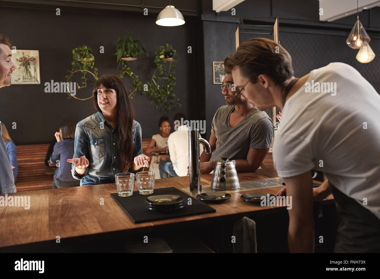 Woman and colleagues at modern coffee shop counter Stock Photo - Alamy