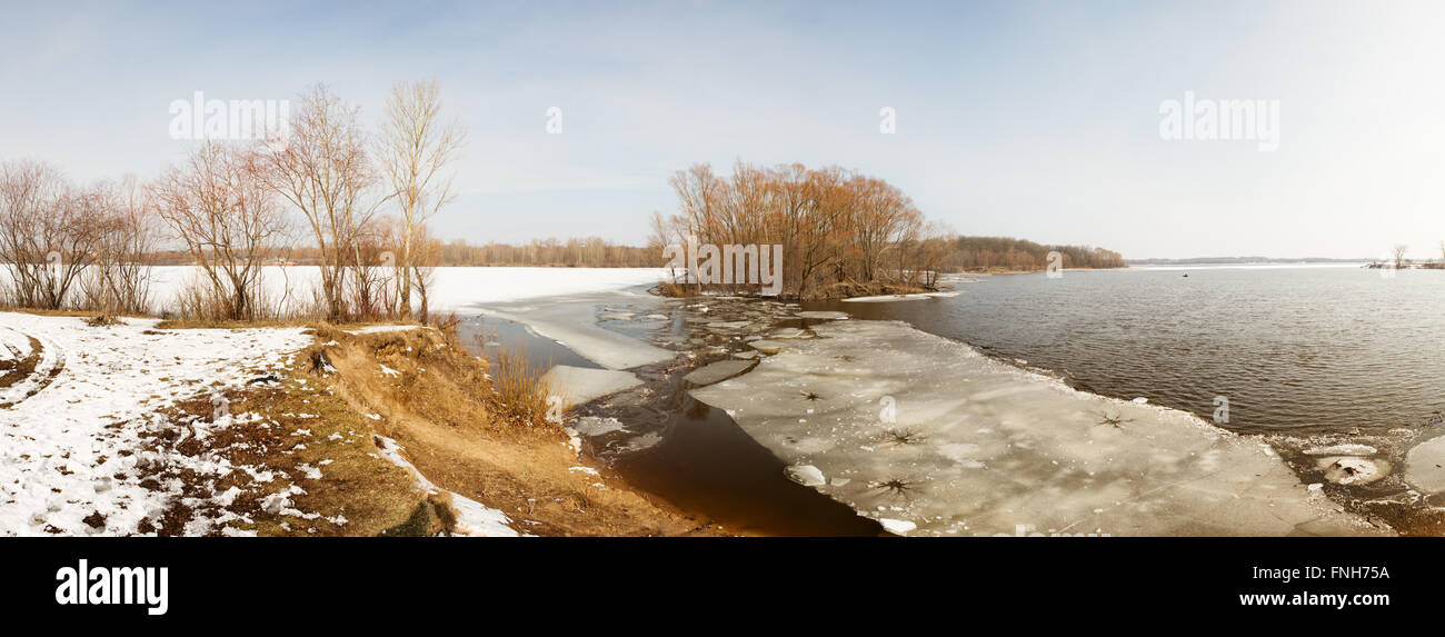 Ice fragments under thin layer of frozen river water. Dark blue natural ...