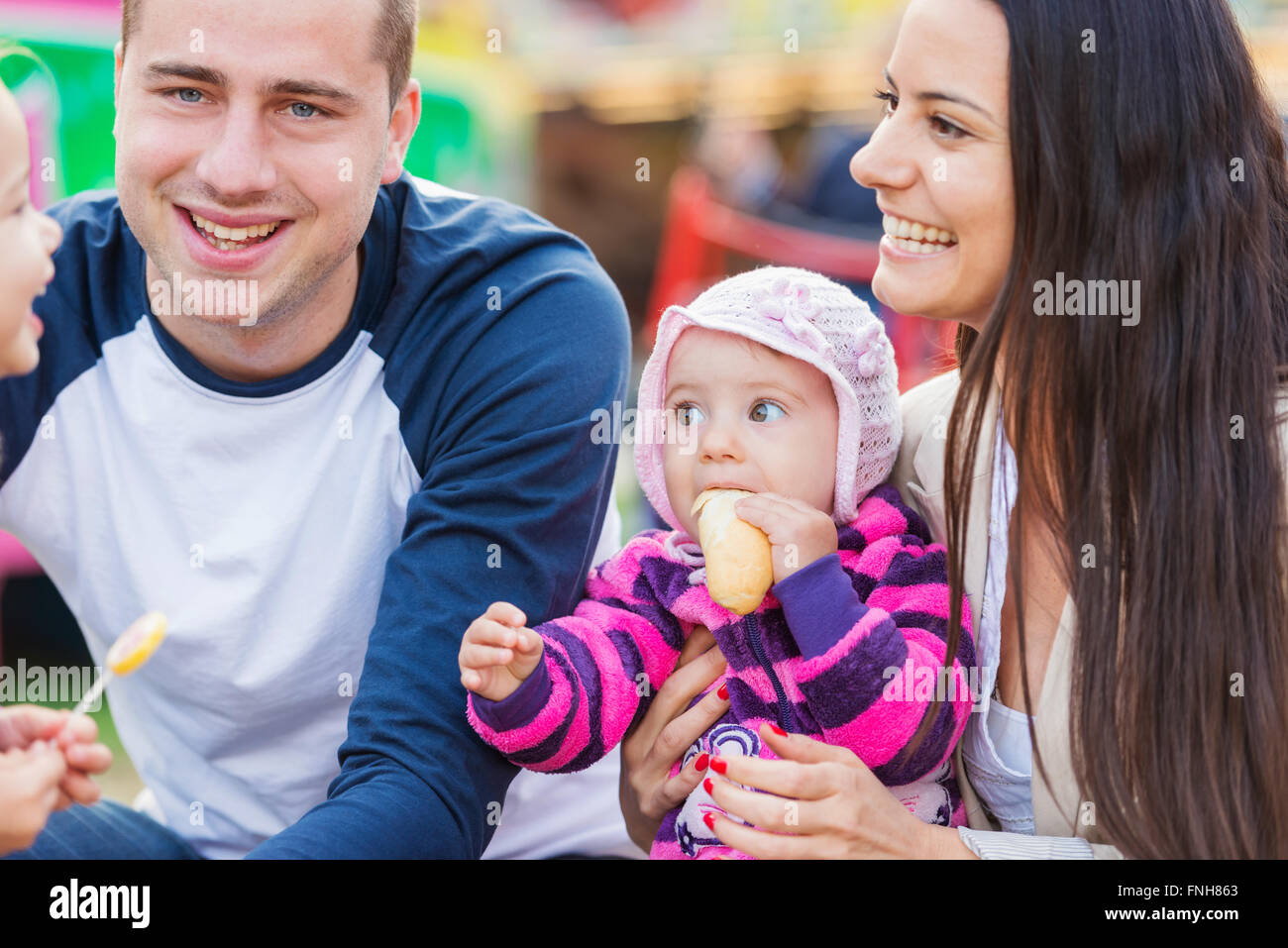Family with little baby enjoying time at fun fair Stock Photo - Alamy