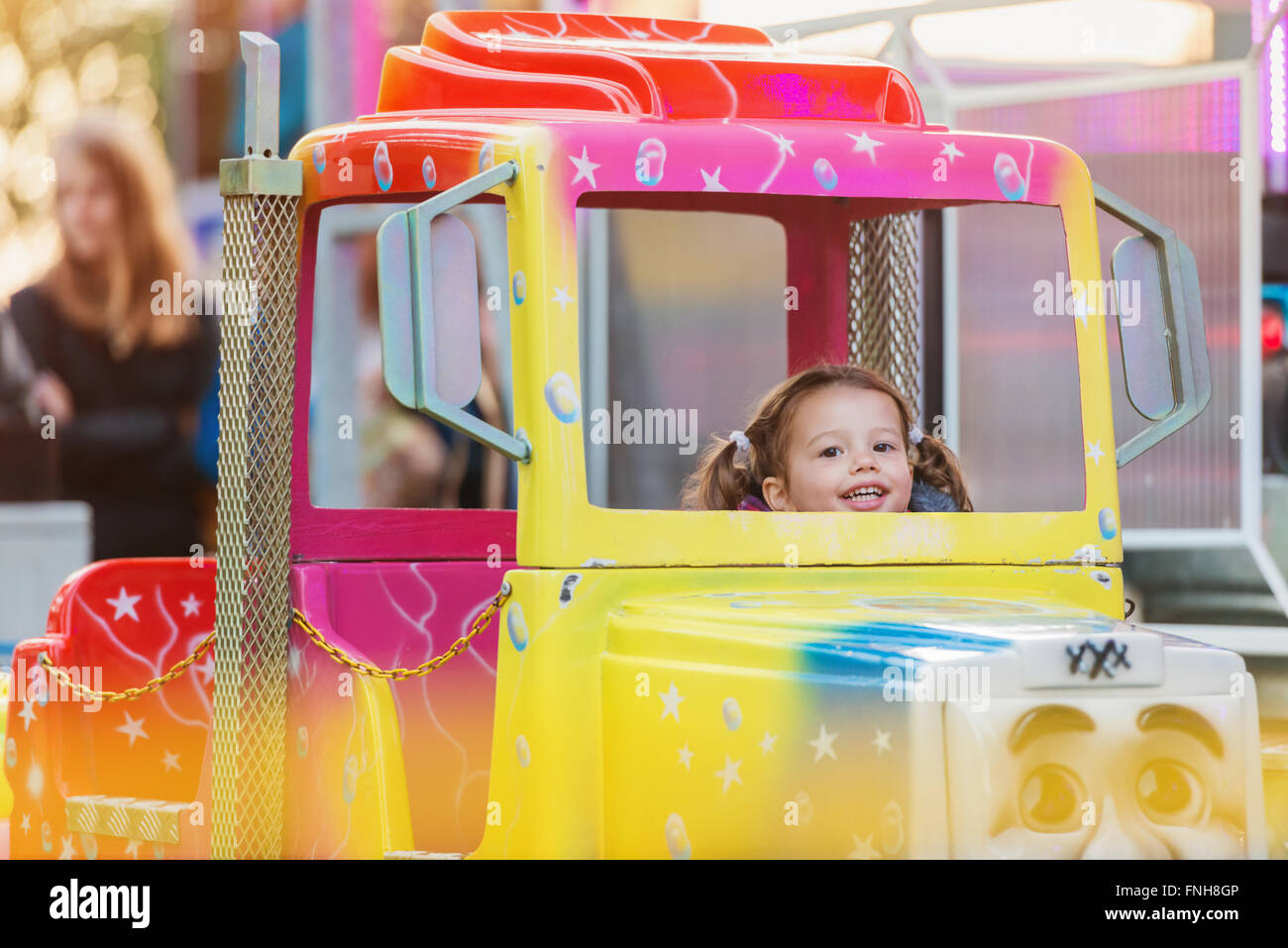 Little girl enjoying fun fair ride, amusement park Stock Photo - Alamy