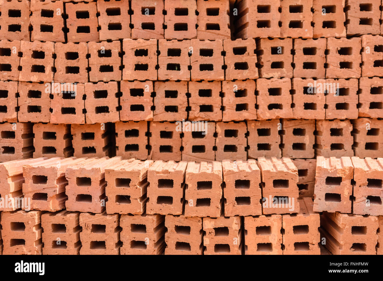 Stack of red clay bricks wall building Stock Photo - Alamy