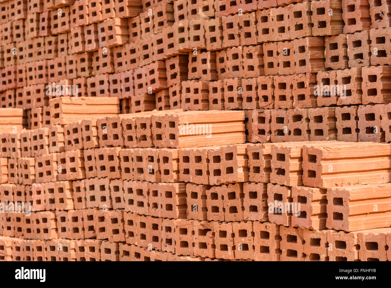 Stack of red clay bricks wall building Stock Photo - Alamy