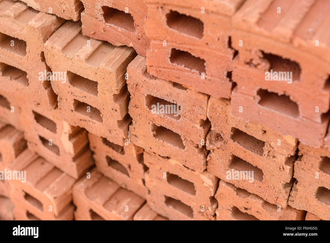 Stack of red clay bricks wall building Stock Photo - Alamy