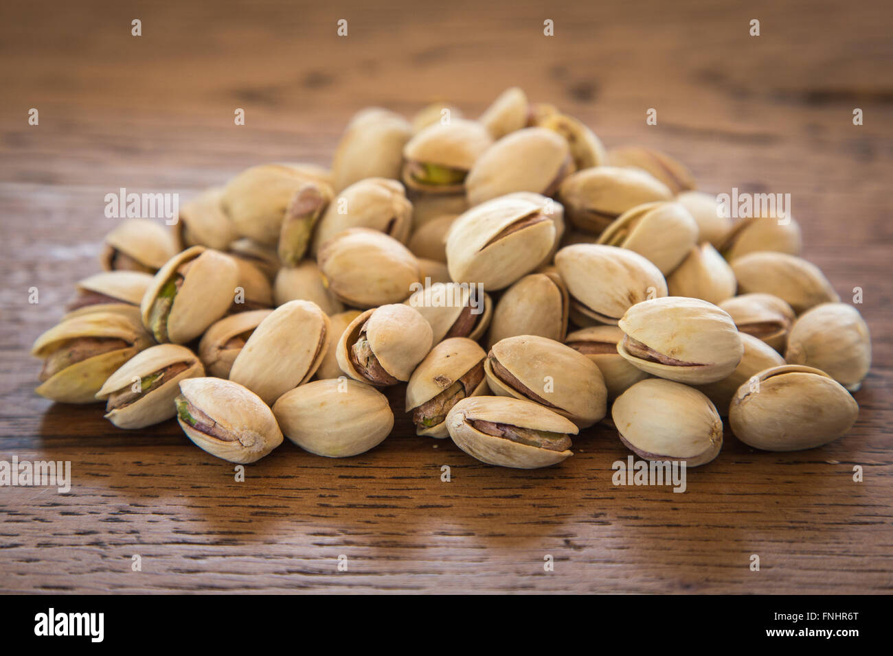 pistachio nuts in their shells on a wooden background Stock Photo - Alamy