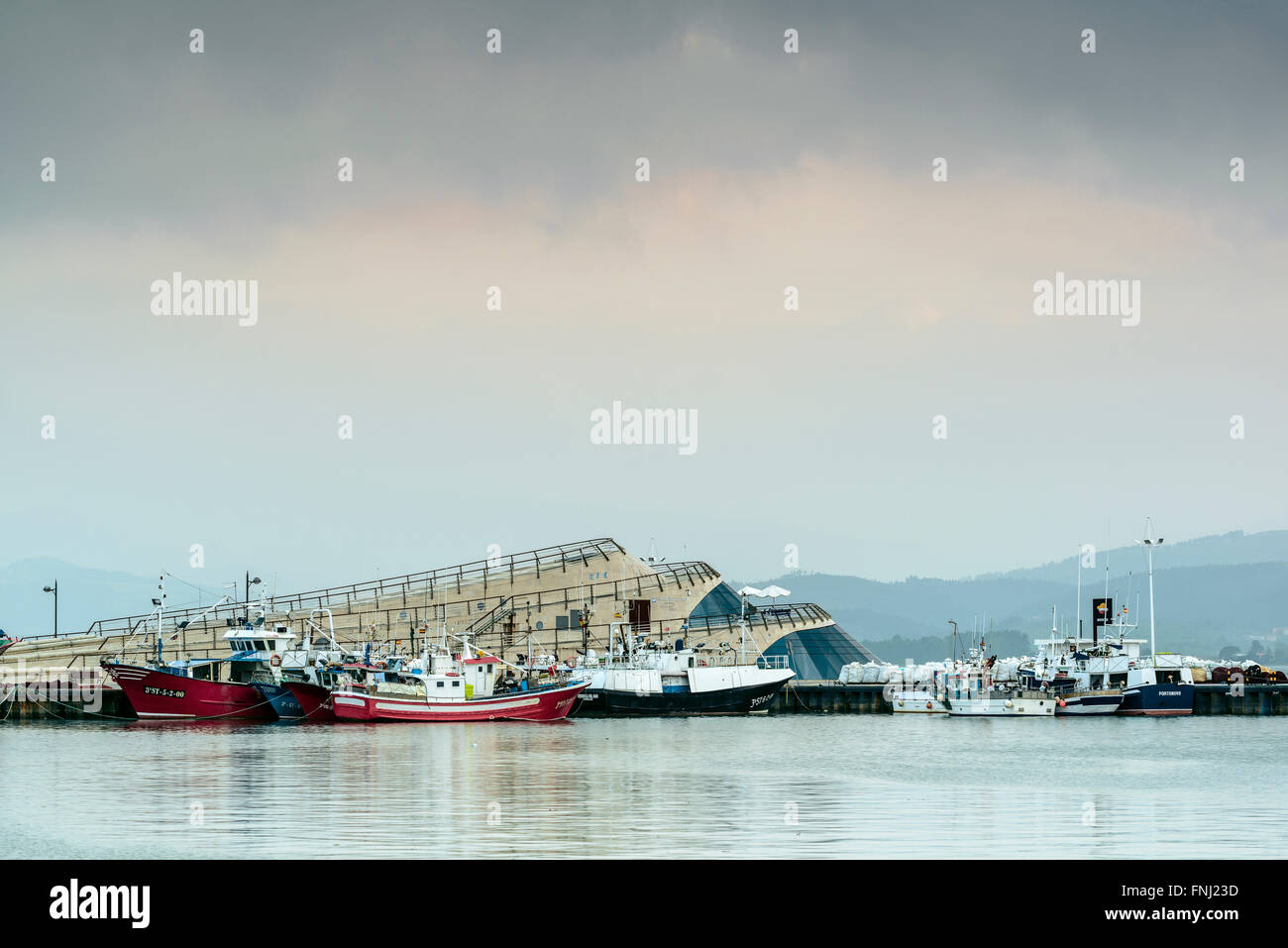 Boat-shaped building at the fishing port with a fishing boat Santoña ...