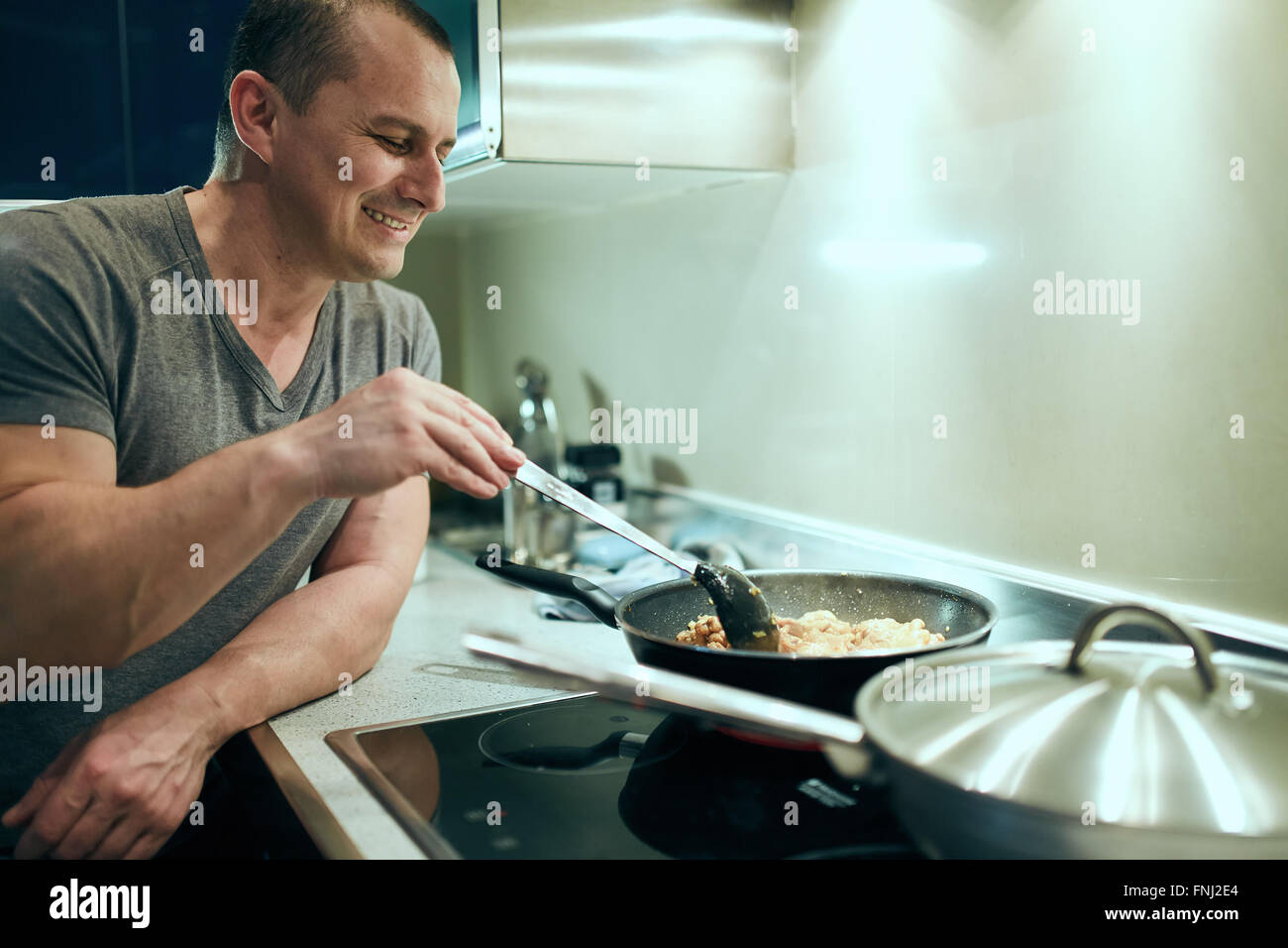 Man cooking at home alone a thai recipe in wok pans Stock Photo - Alamy