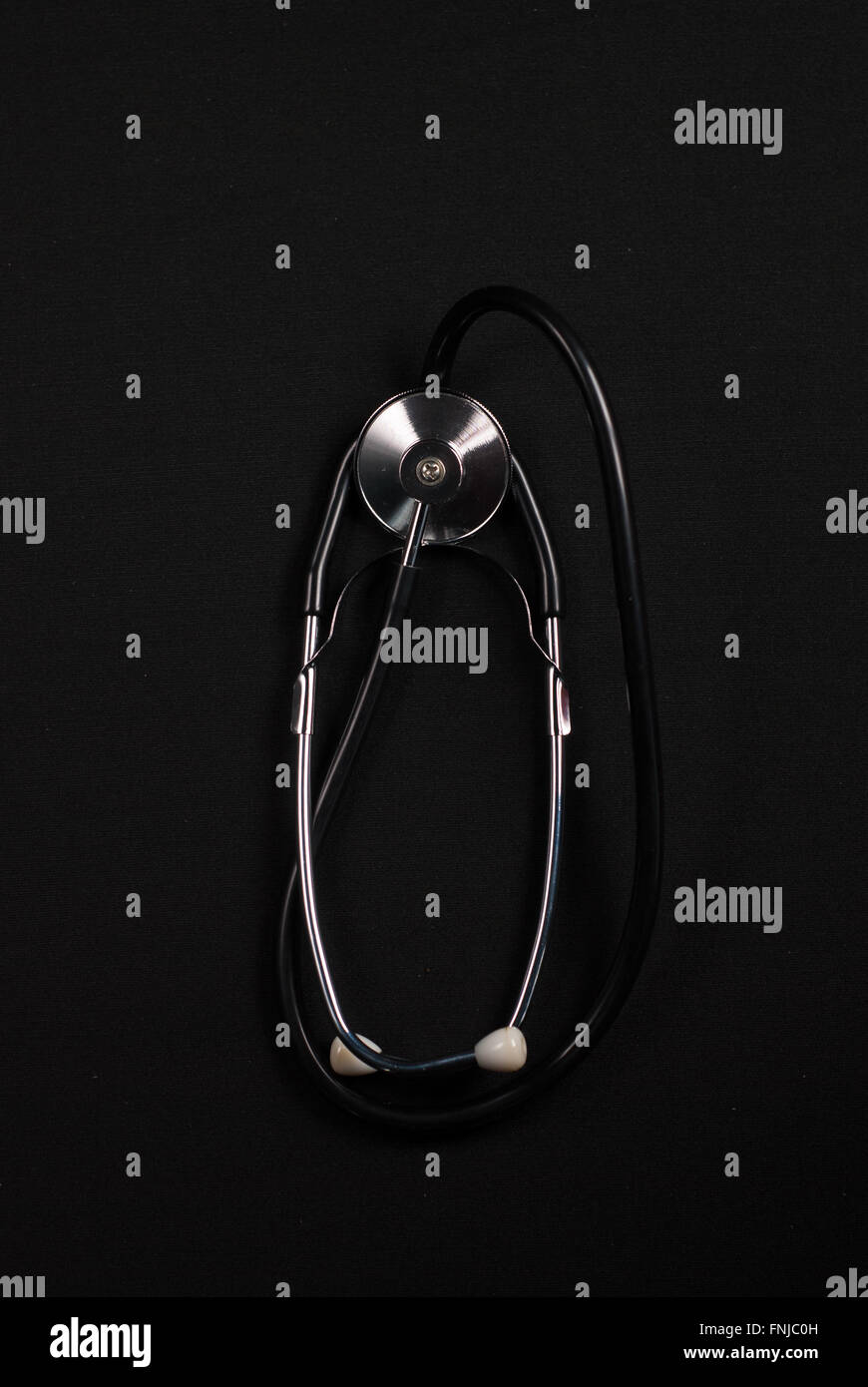 The metal stethoscope on a black background, with reflections of light ...