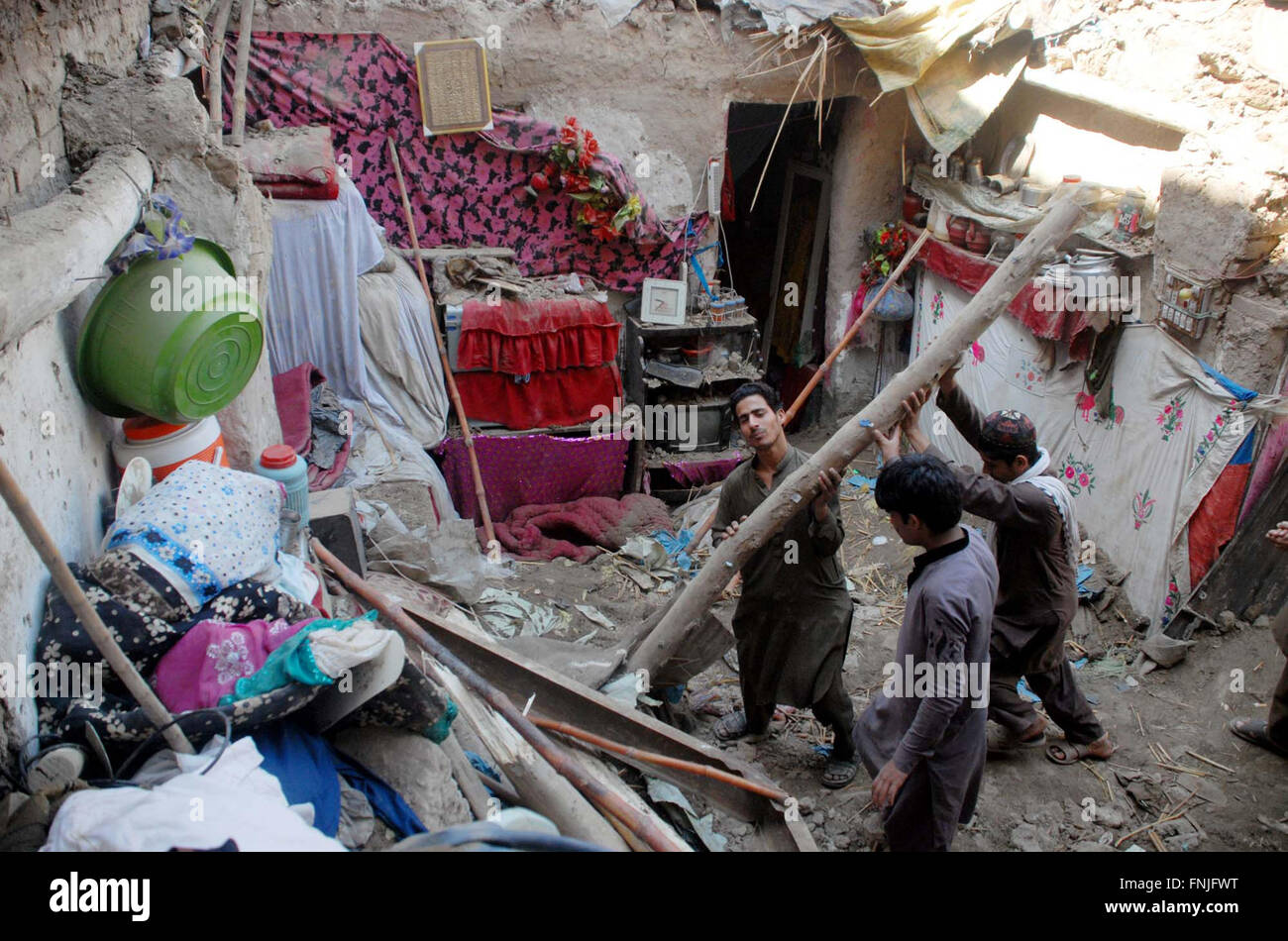 People look damaged stuff which was destroyed when roof of their house ...