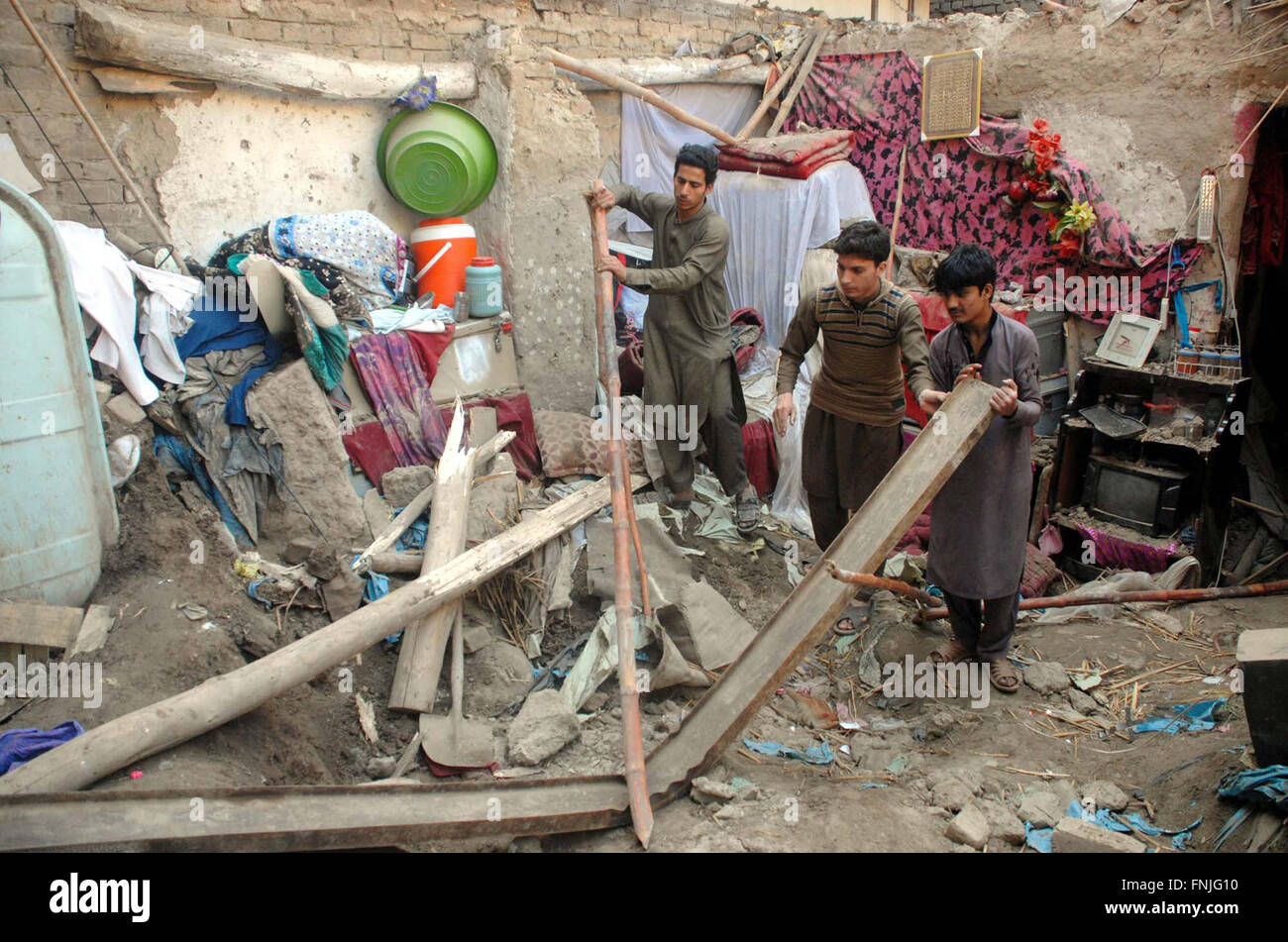 People look damaged stuff which was destroyed when roof of their house ...