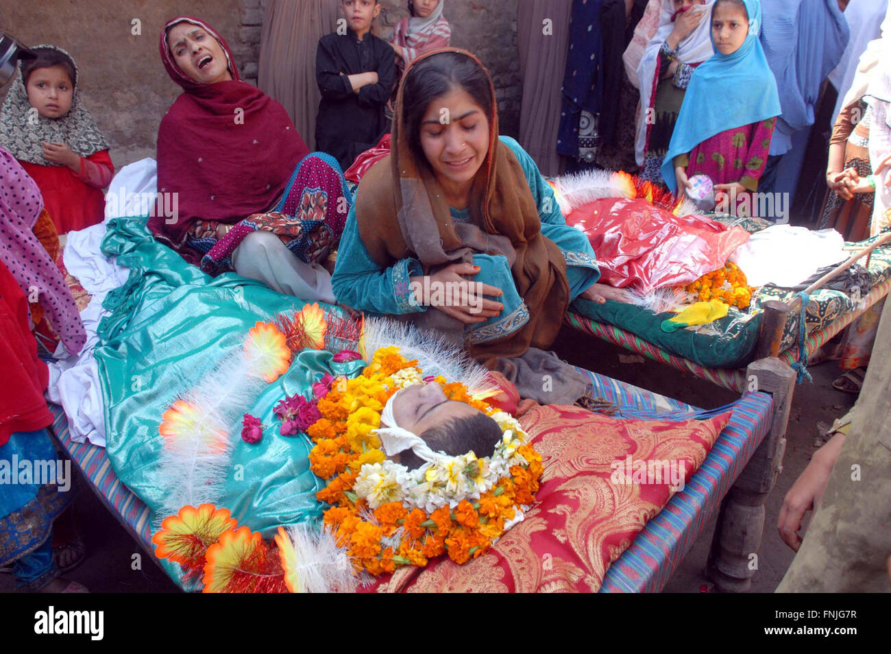 Women mourn over the dead bodies of her children, who were lost their ...