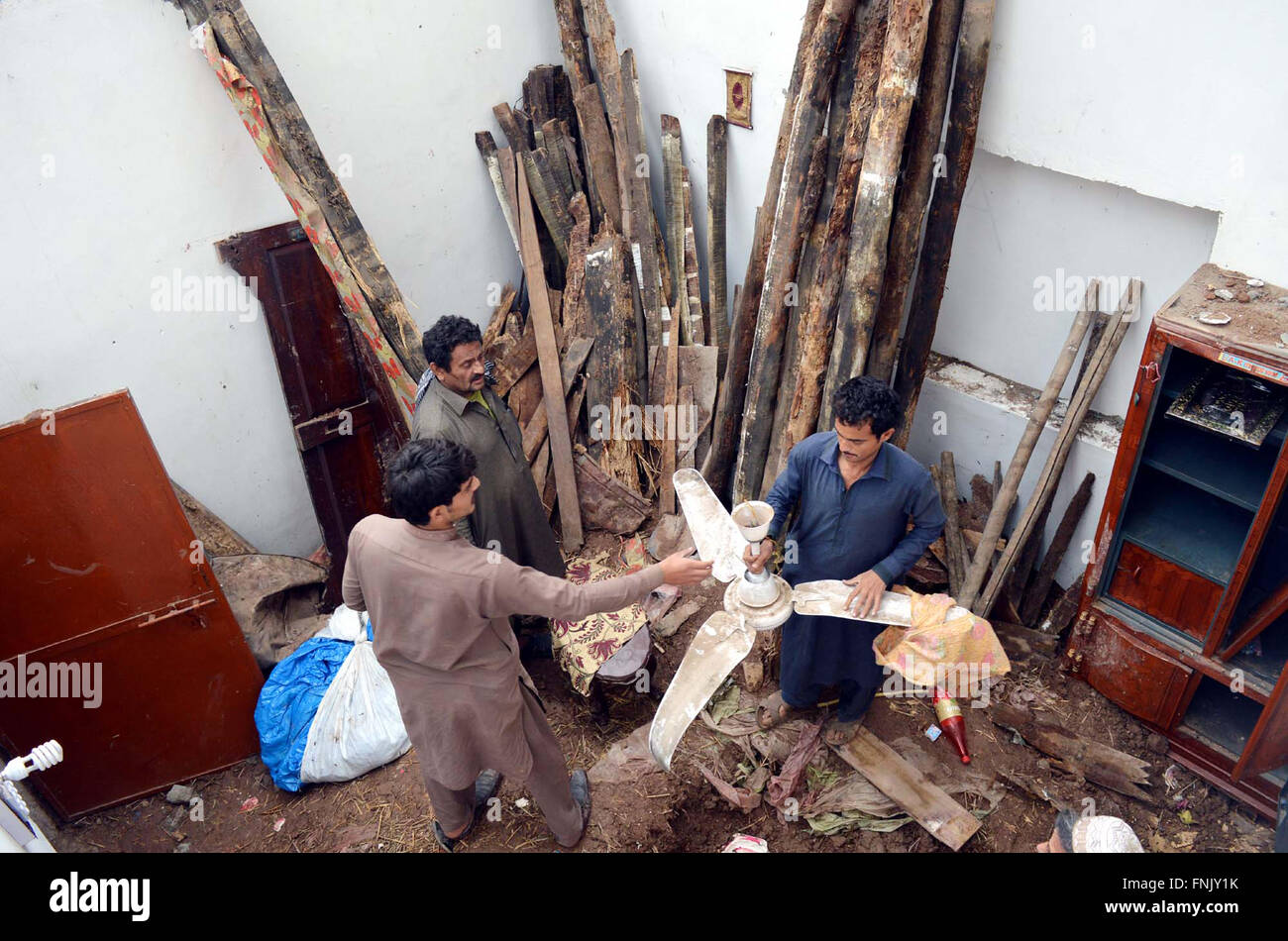 People clear damaged stuff which was destroyed when roof of their house ...