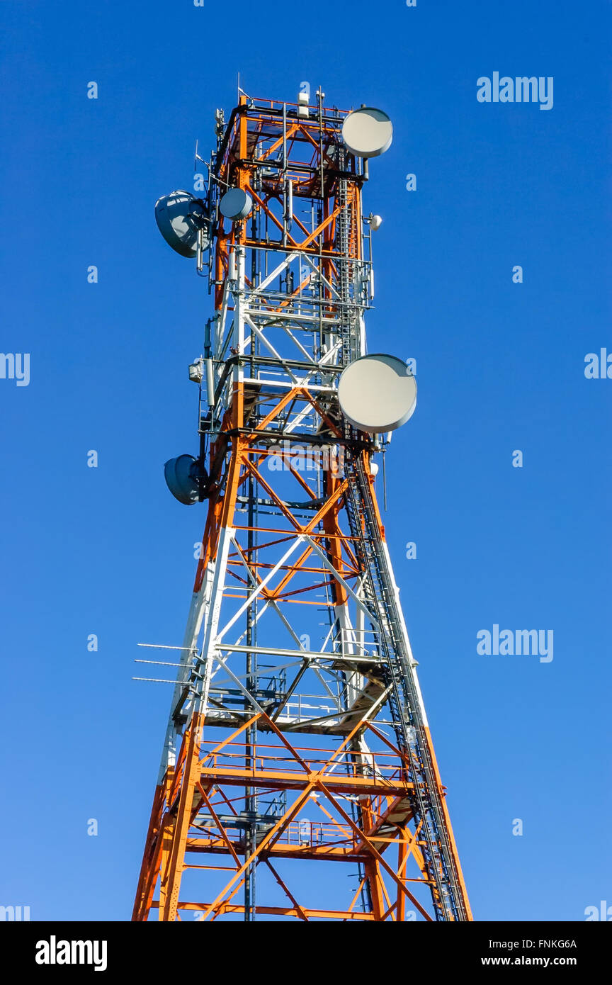 Radio/Telecommunication Tower in white and orange with blue sky Stock ...
