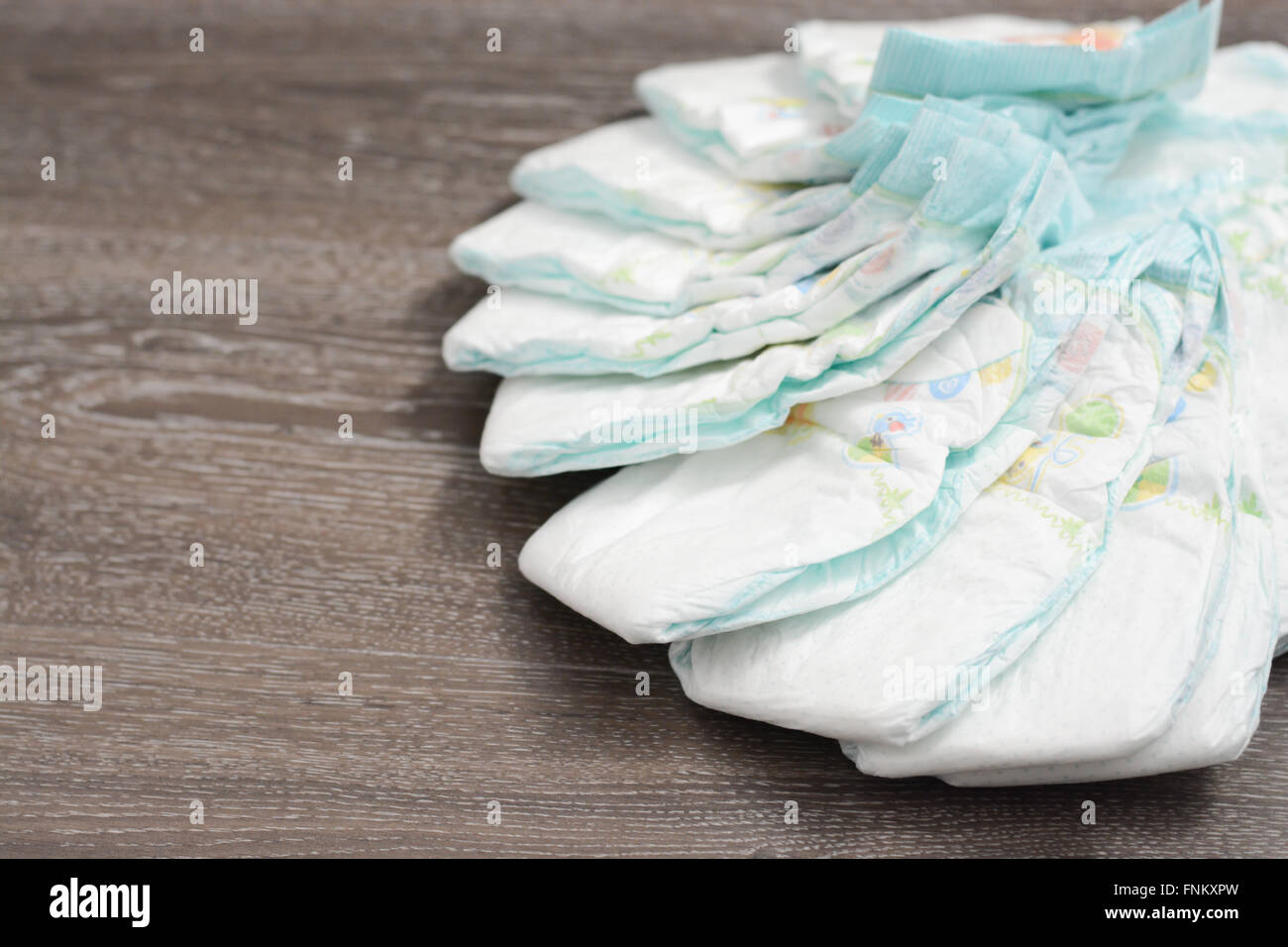 Pile or stack of baby diapers isolated on wooden floor Stock Photo - Alamy