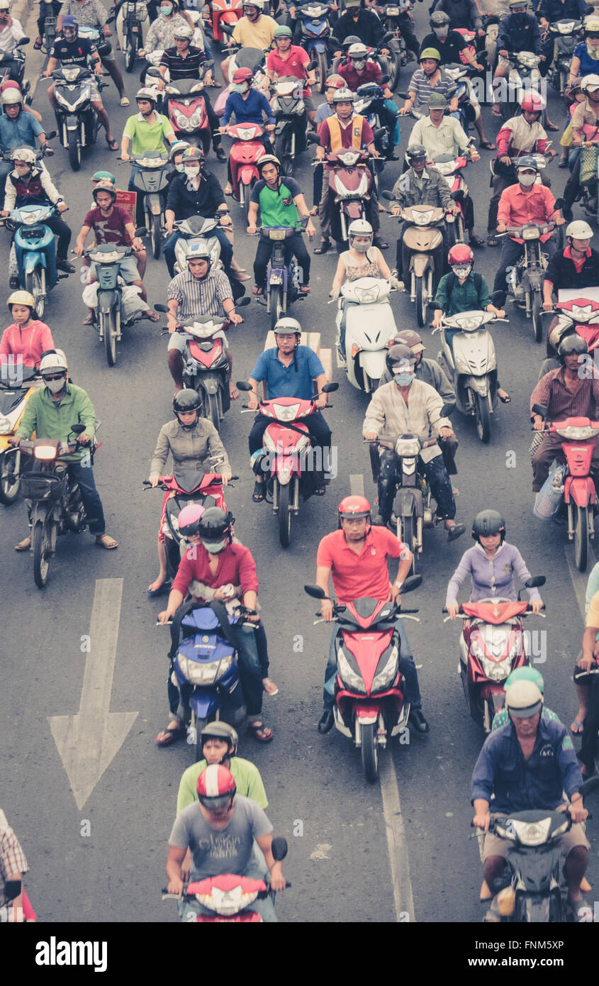 motorbike traffic in saigon - many scooter drivers , crowded street ...