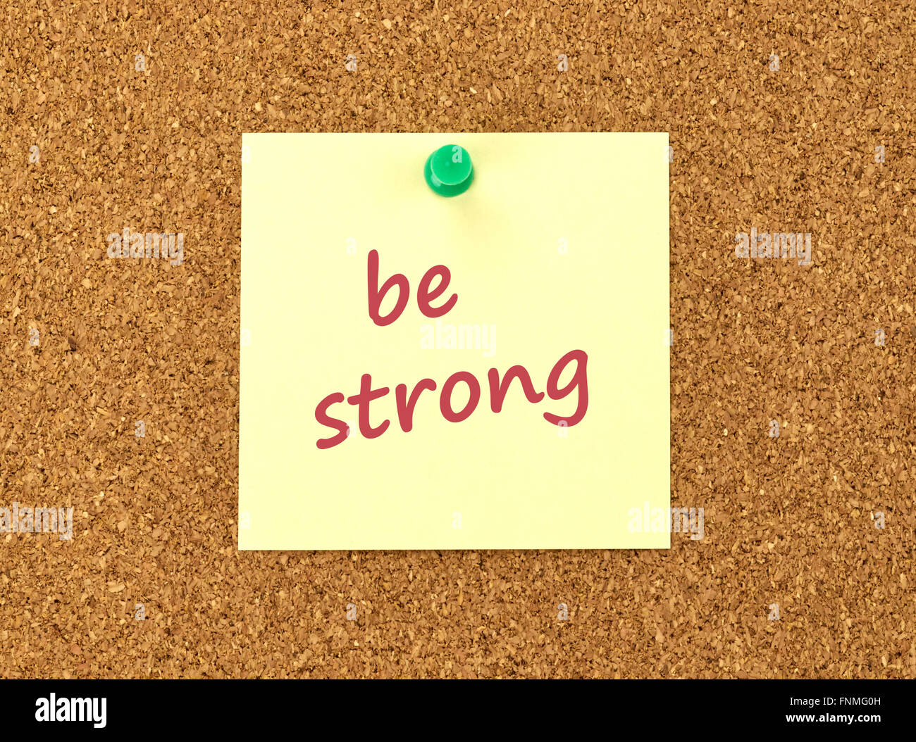 The phrase Be Strong in red text on a yellow sticky note posted to a ...