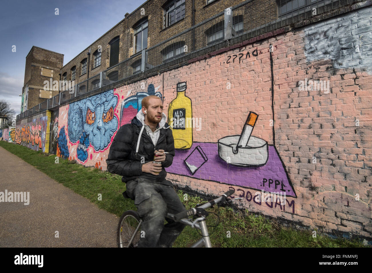 cyclist on canal path london smoking cyclist Stock Photo - Alamy