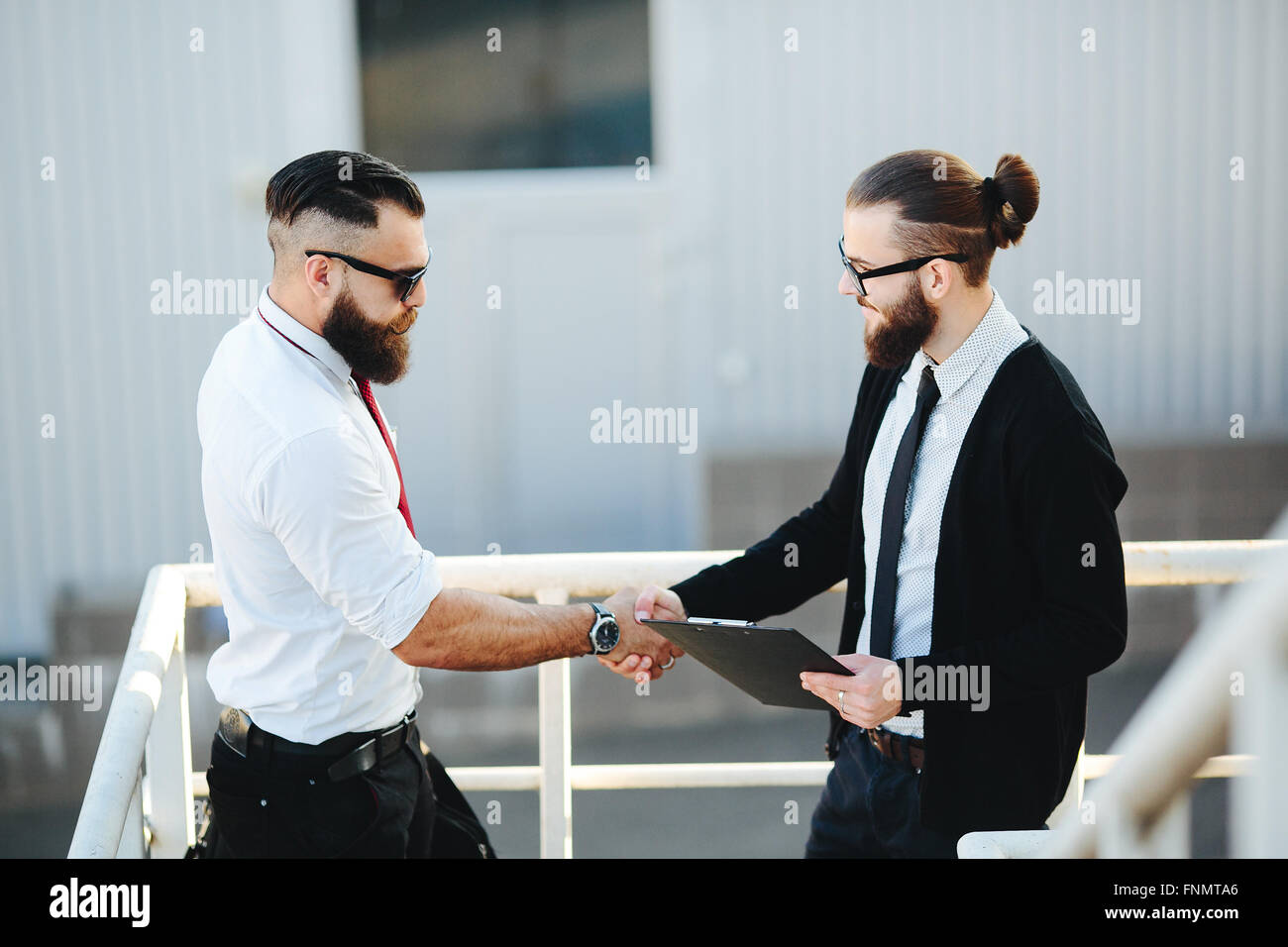 Two businessmen shaking hands Stock Photo - Alamy