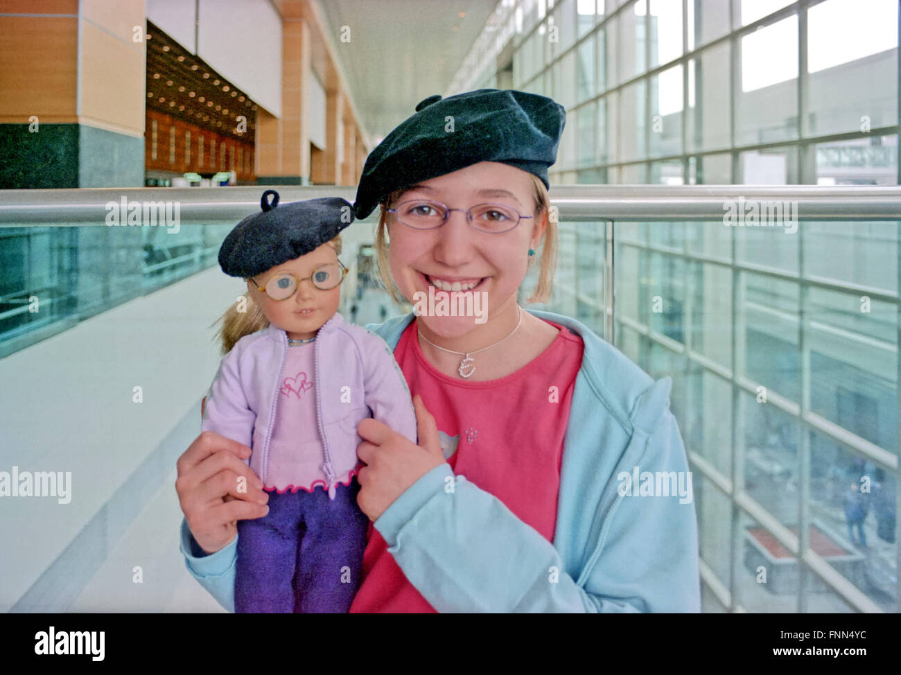 A little girl and her doll with matching berets in the airport (Logan ...