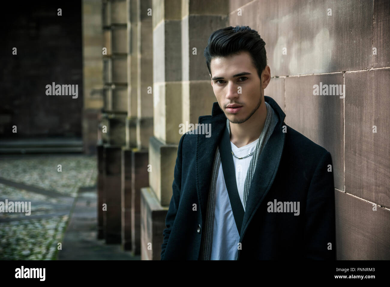 Handsome young man outdoor in winter fashion, wearing black coat and ...