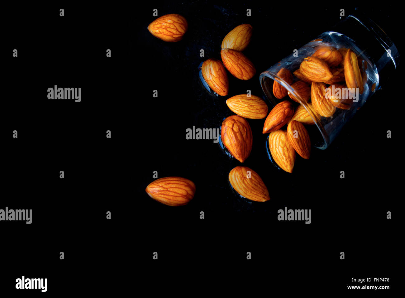 Nuts of almonds are filled to a drop form. on black background Stock ...