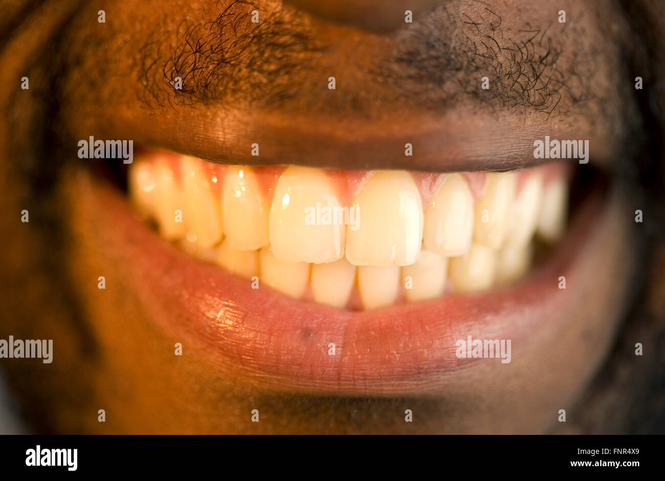 Close-up of a person smiling wide to show their teeth Stock Photo - Alamy
