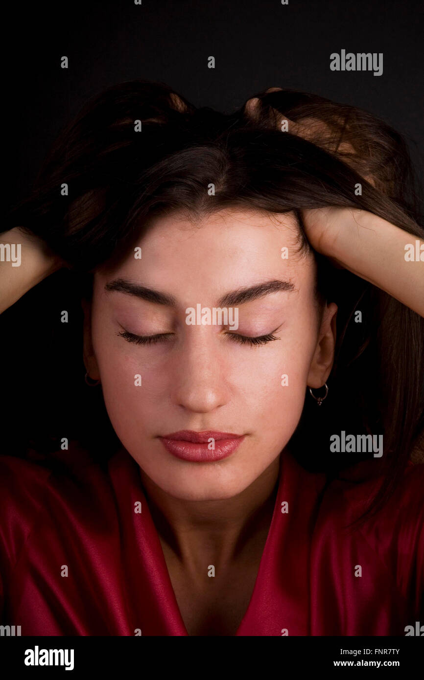 Woman running her hands through her hair Stock Photo - Alamy