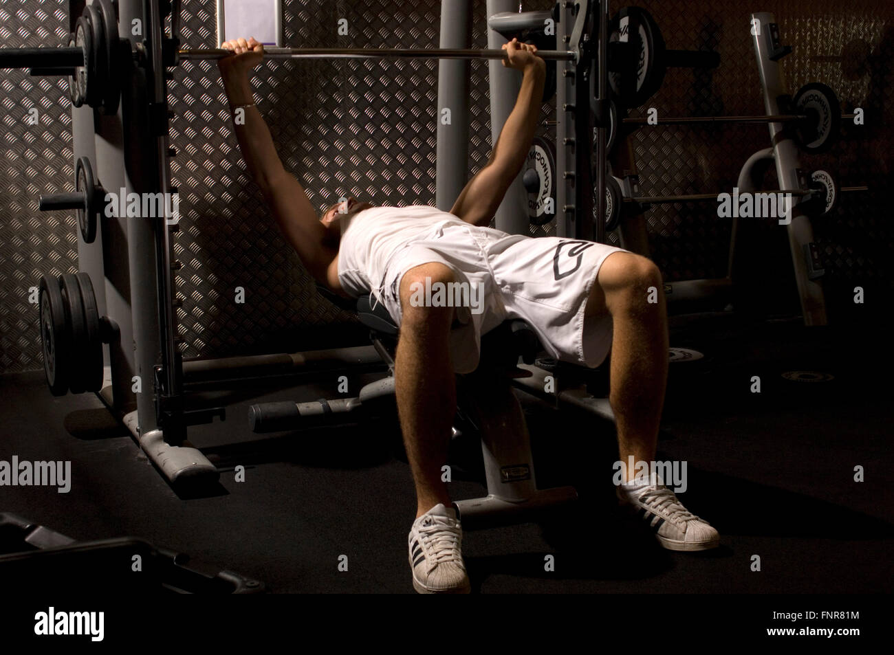 A man exercising by using gym equipment Stock Photo - Alamy