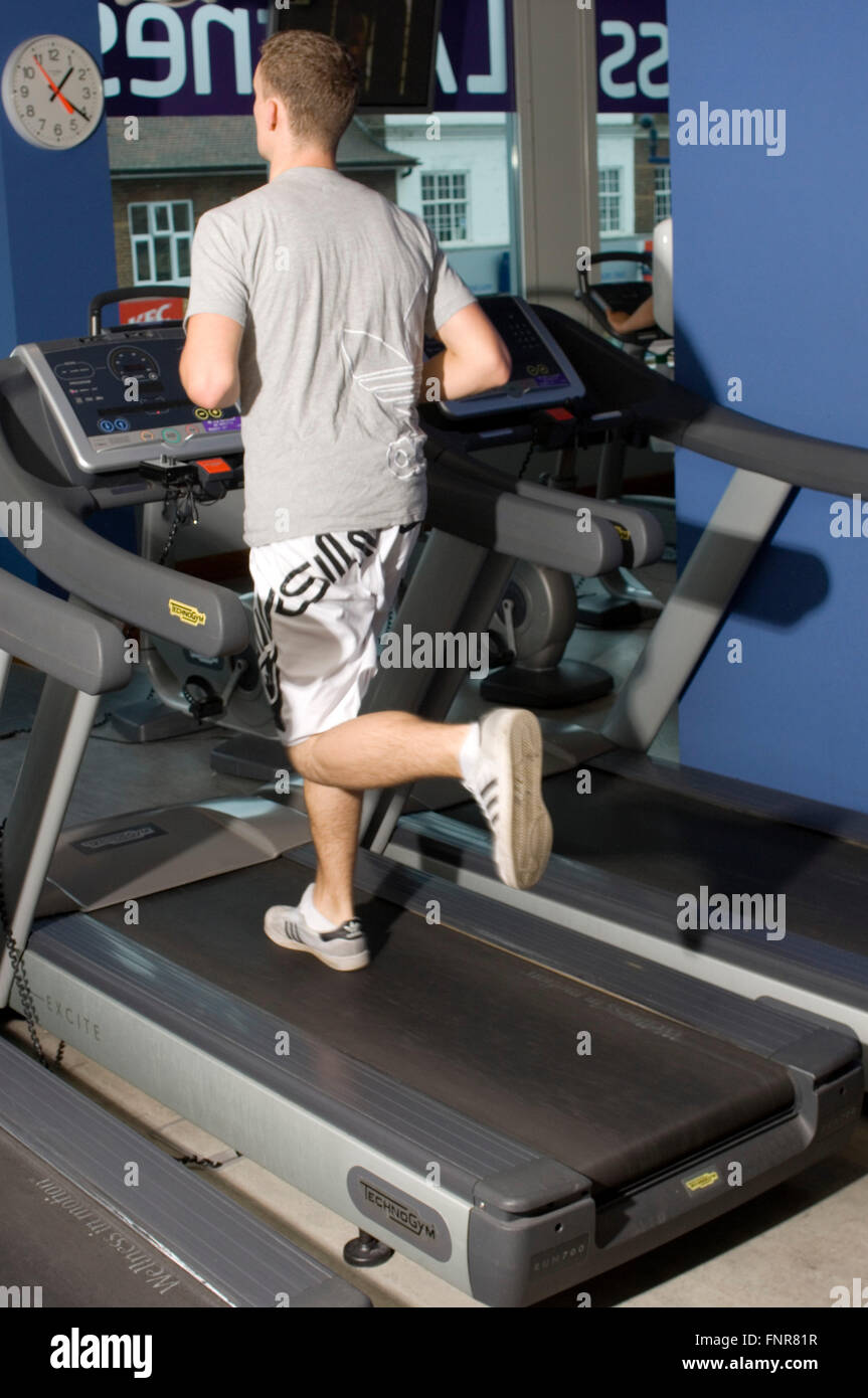 A man running on a treadmill in a gym Stock Photo - Alamy