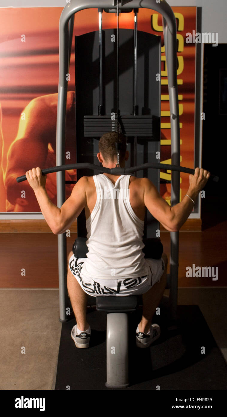 A man exercising by using gym equipment Stock Photo - Alamy