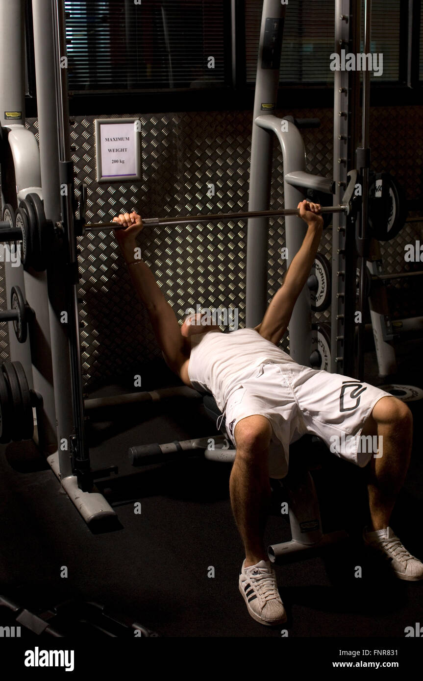 A man exercising by using gym equipment Stock Photo - Alamy