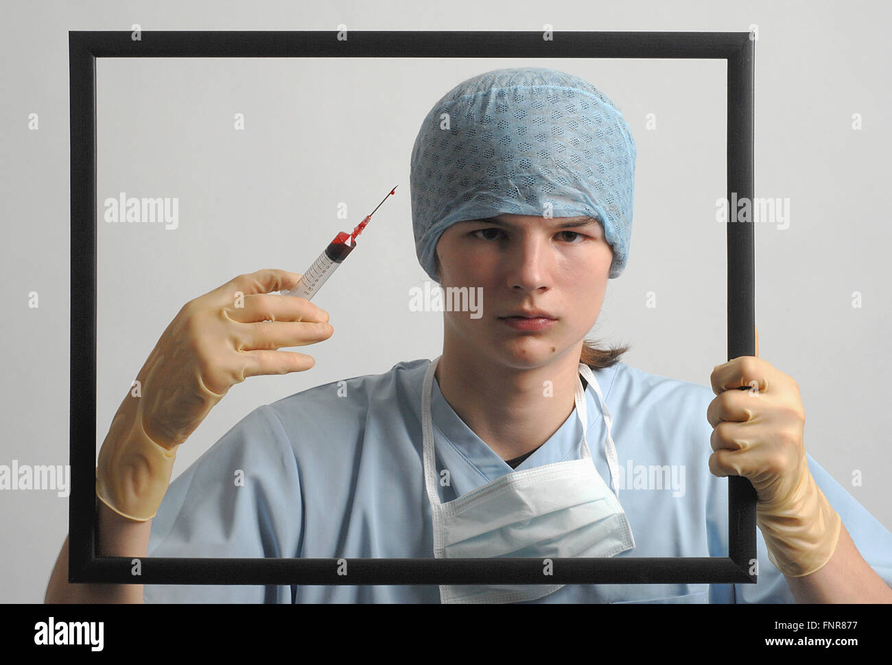 A young surgeon holding needle seen through a frame Stock Photo - Alamy