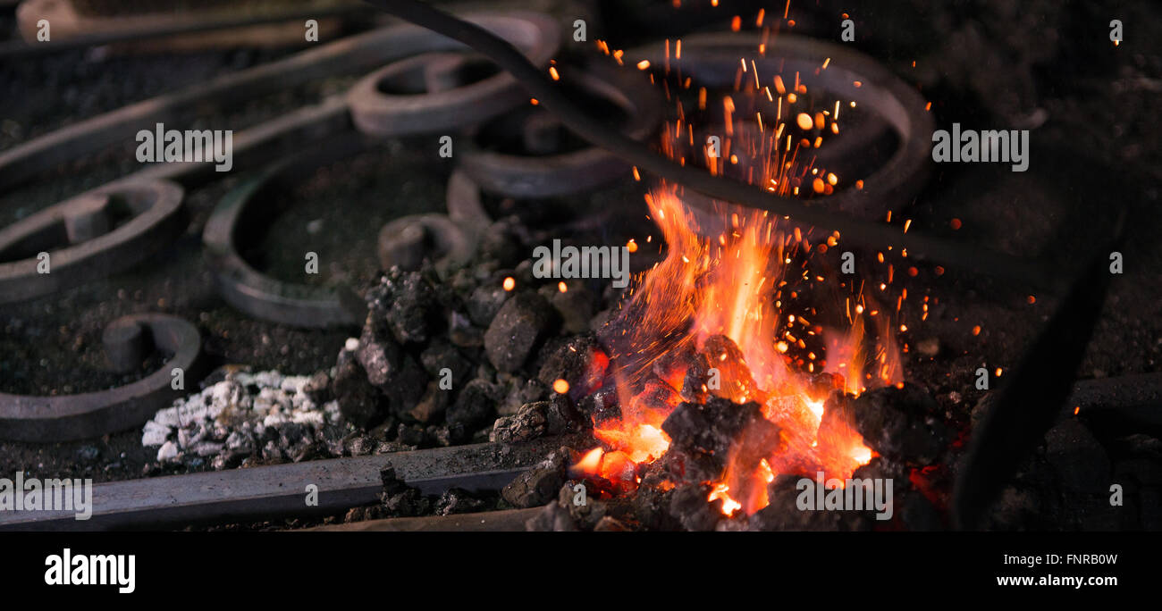 Ironworker forging hot iron in workshop Stock Photo - Alamy