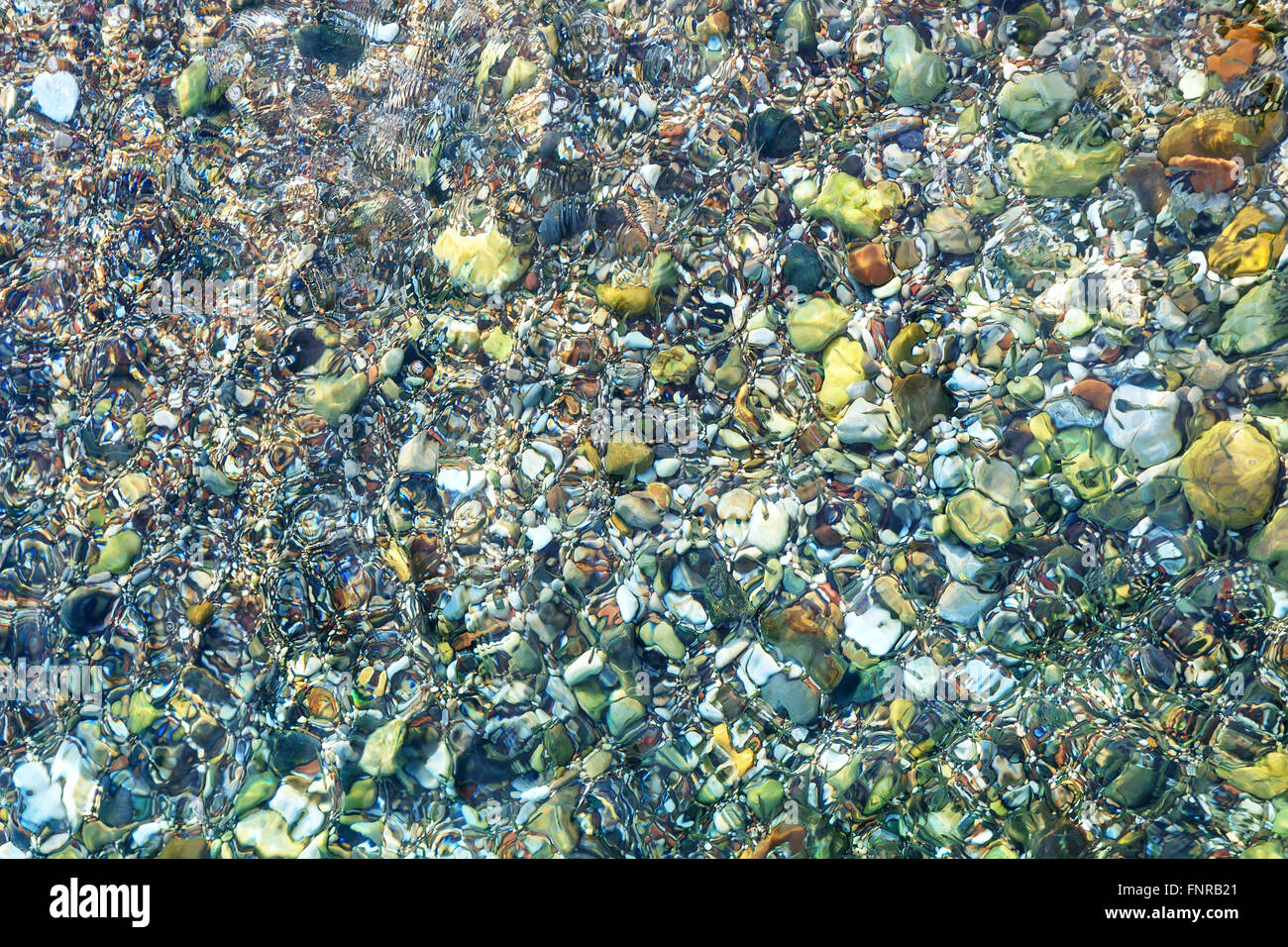 Colourful Pebble under blue water, abstract background Stock Photo - Alamy