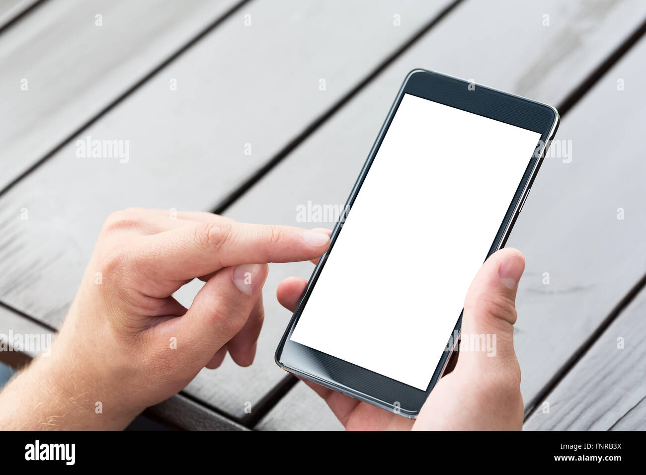Man holding smart mobile phone on wooden table background Stock Photo ...
