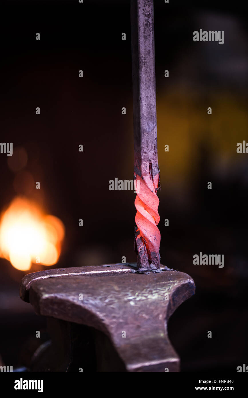 Ironworker forging hot iron in workshop Stock Photo - Alamy