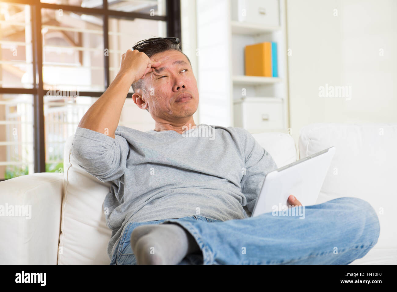 asian male with sore eyes when using too much gadgets Stock Photo - Alamy