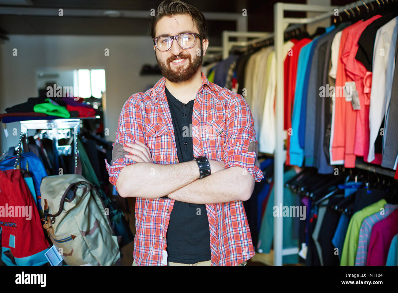Portrait of young handsome salesman standing in clothing store Stock ...