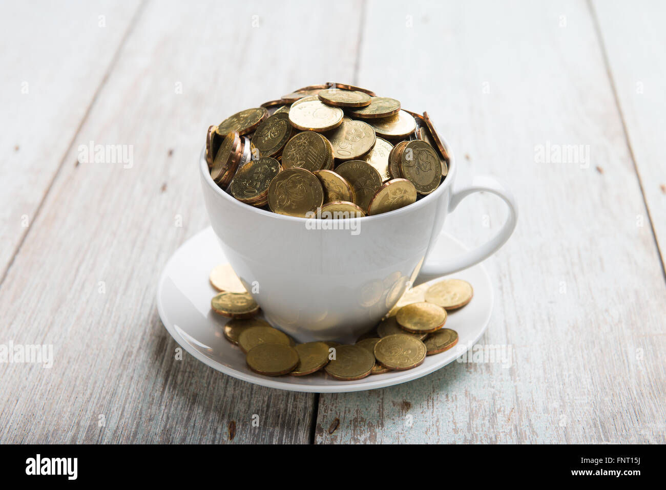 gold coins on coffee cup Stock Photo - Alamy